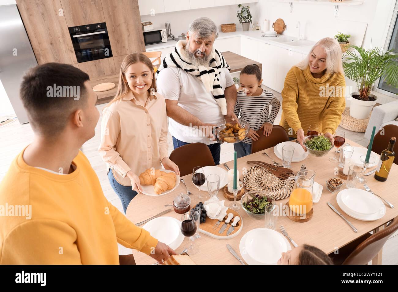 Big family setting dining table in kitchen Stock Photo - Alamy