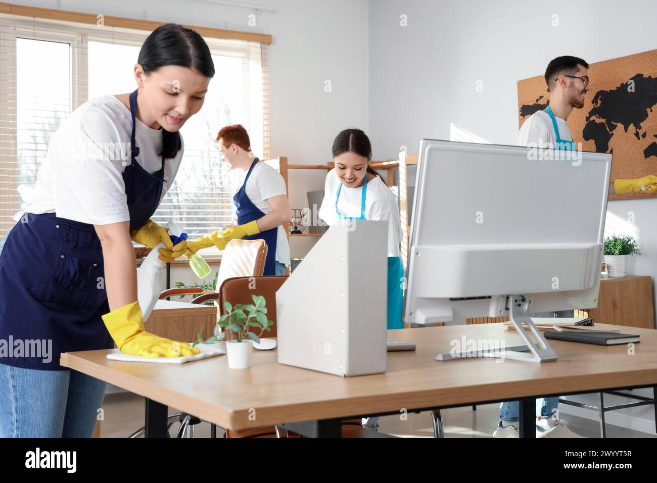 Female janitor cleaning table in office Stock Photo - Alamy