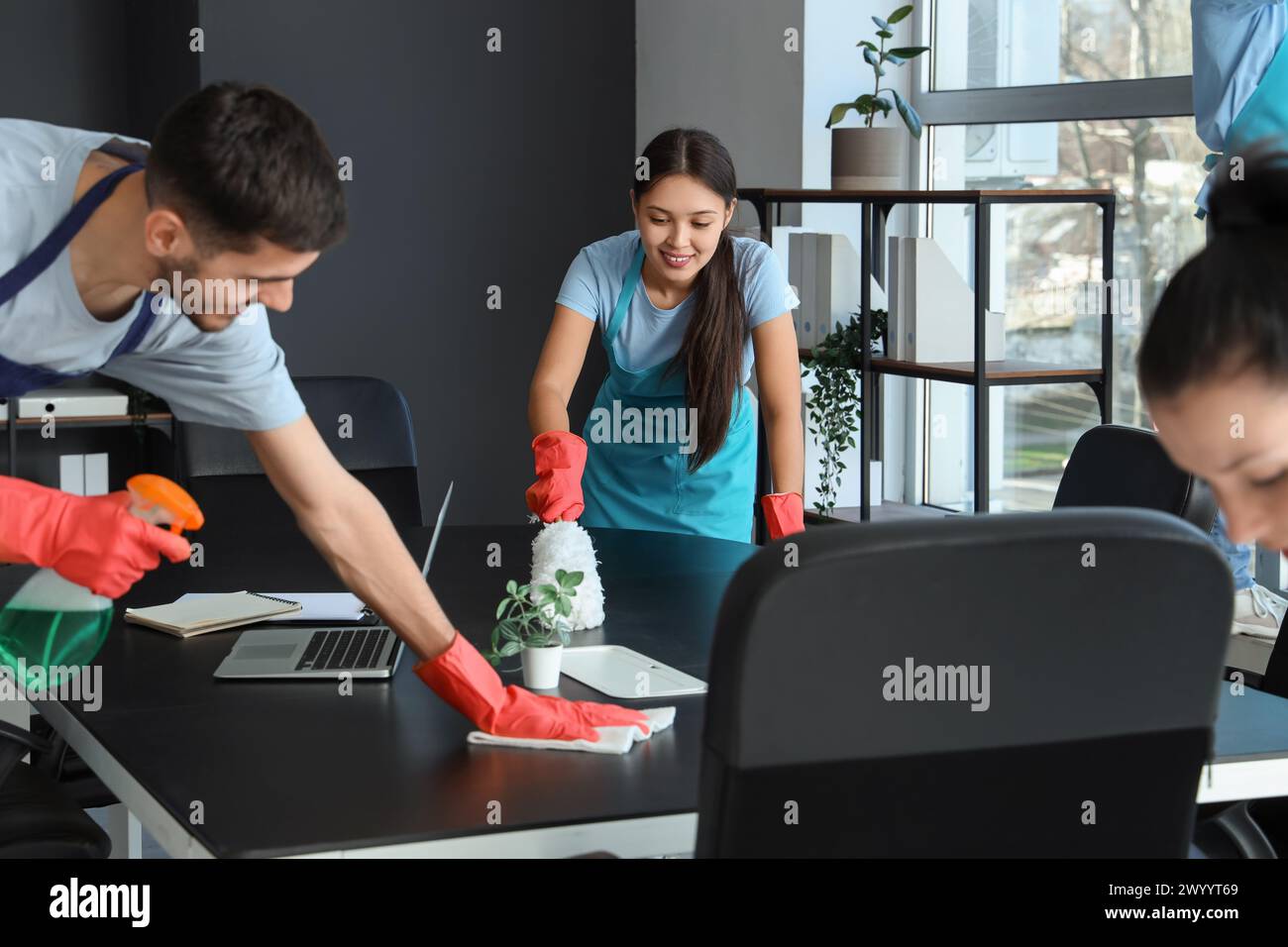 Female Asian janitor cleaning table in office Stock Photo - Alamy