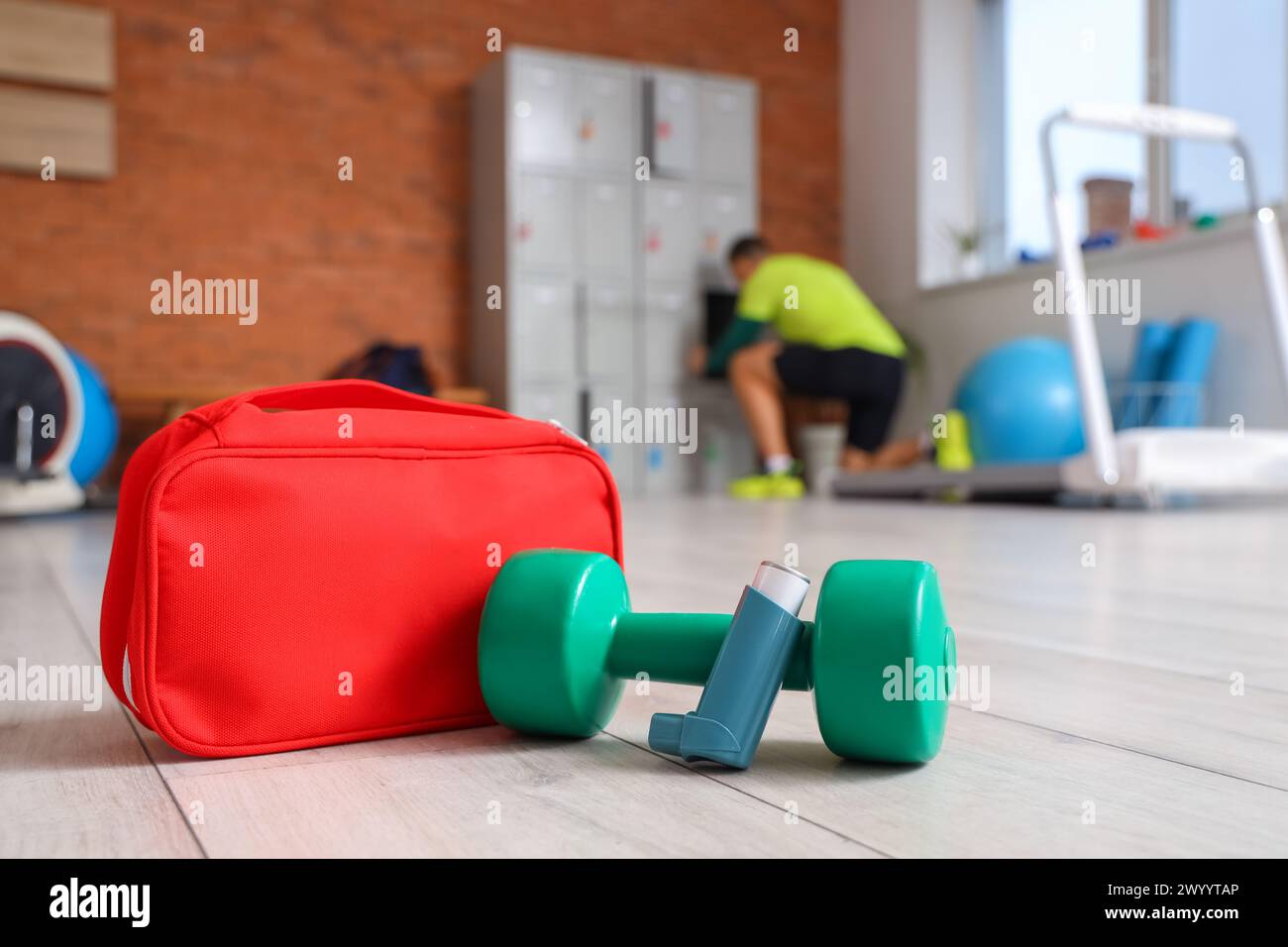 Asthma inhaler with first aid kit and dumbbell in gym, closeup Stock ...