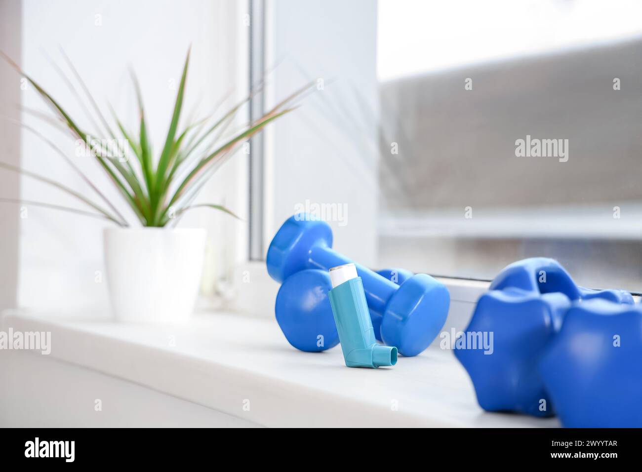 Asthma inhaler with dumbbells on windowsill in gym, closeup Stock Photo ...