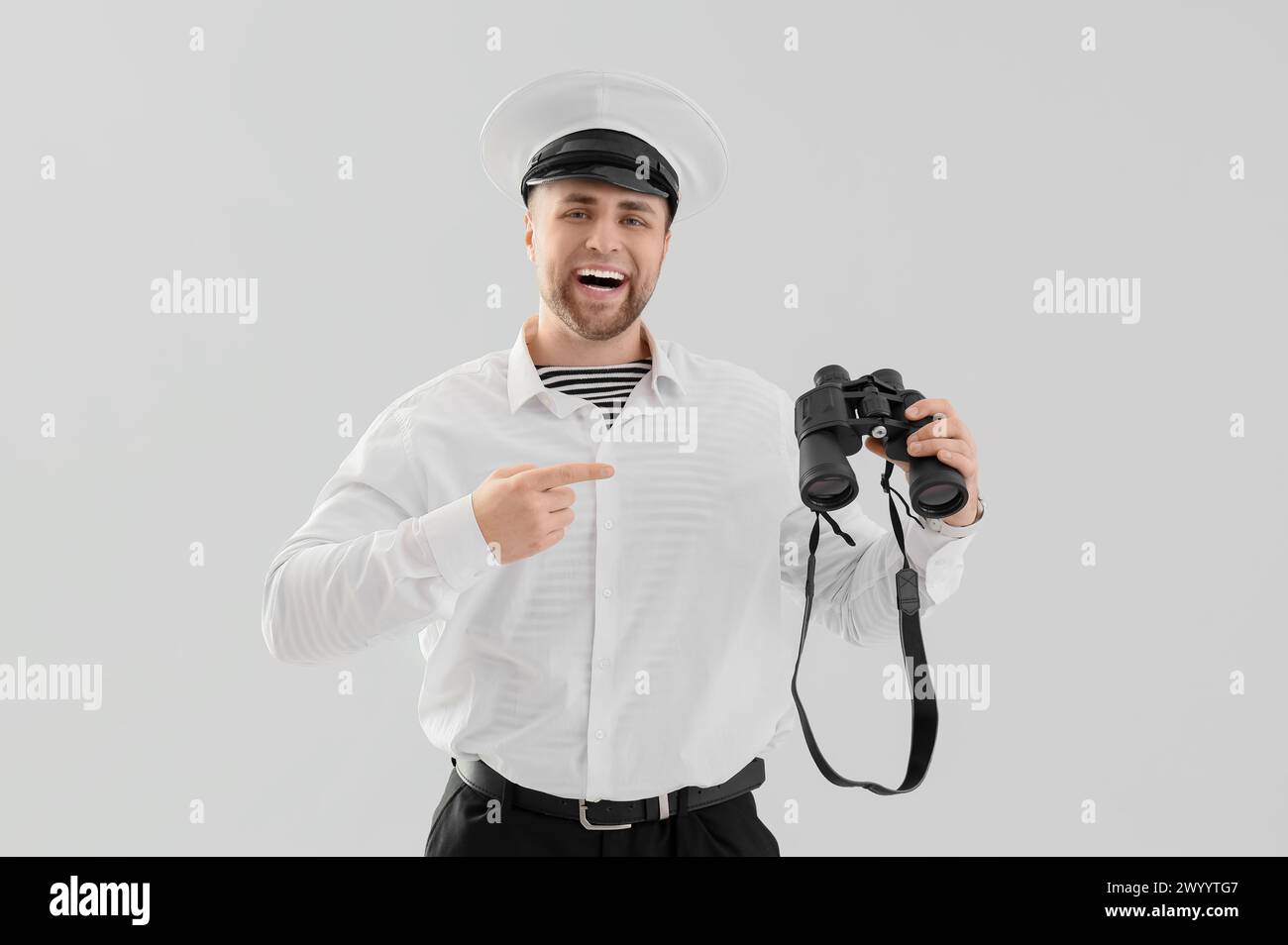 Young male sailor pointing at binoculars on white background Stock ...