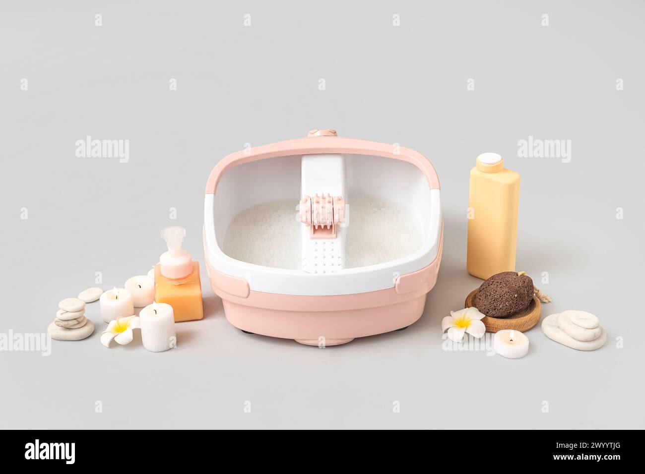 Massage foot bath, cosmetic products, pumice and spa stones on grey ...