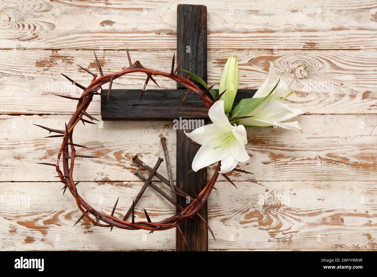 Cross, crown of thorns, white lilies and nails on wooden background Stock Photo - Alamy