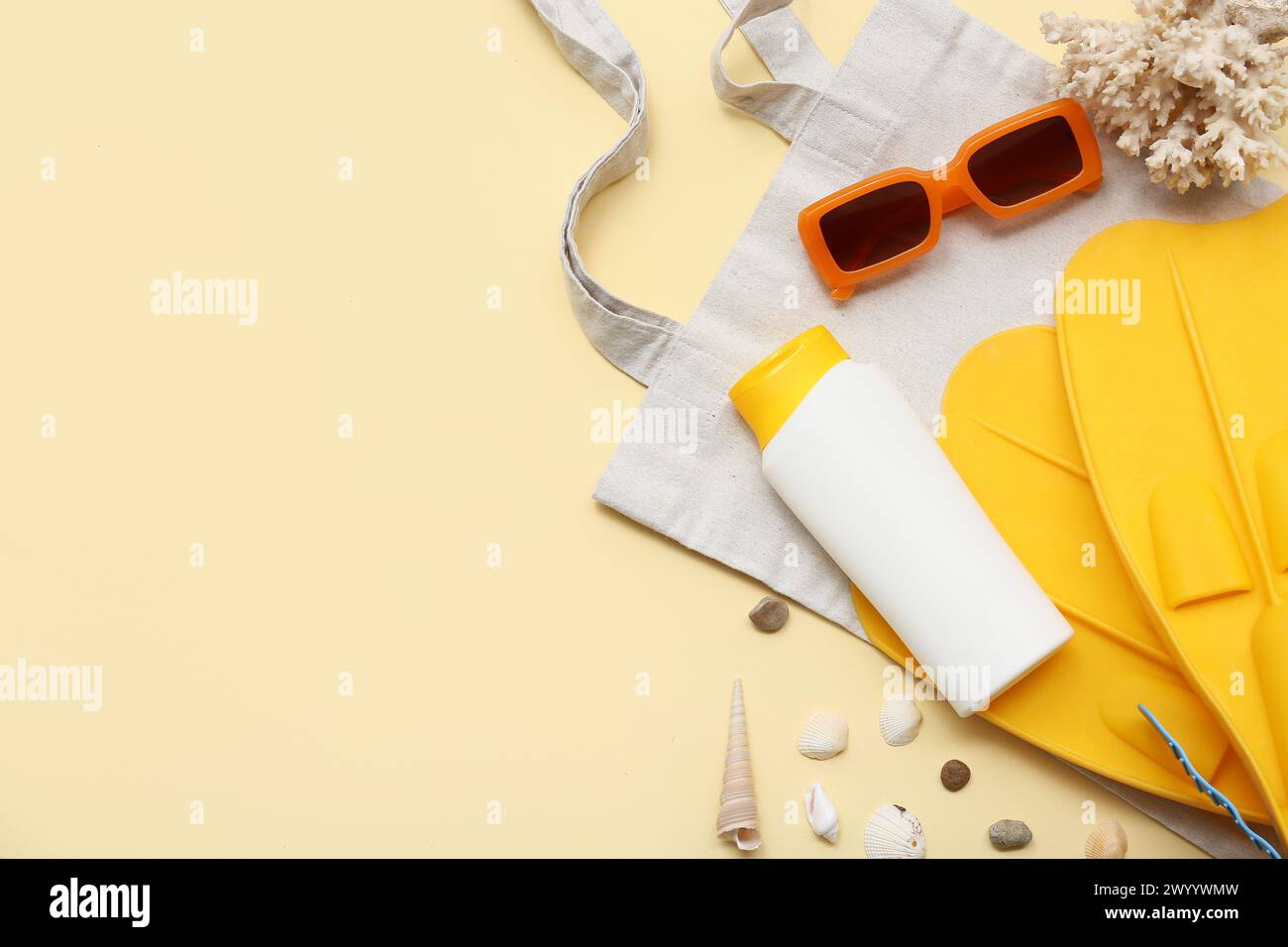 Beach accessories and bottle of sunscreen on beige background Stock ...