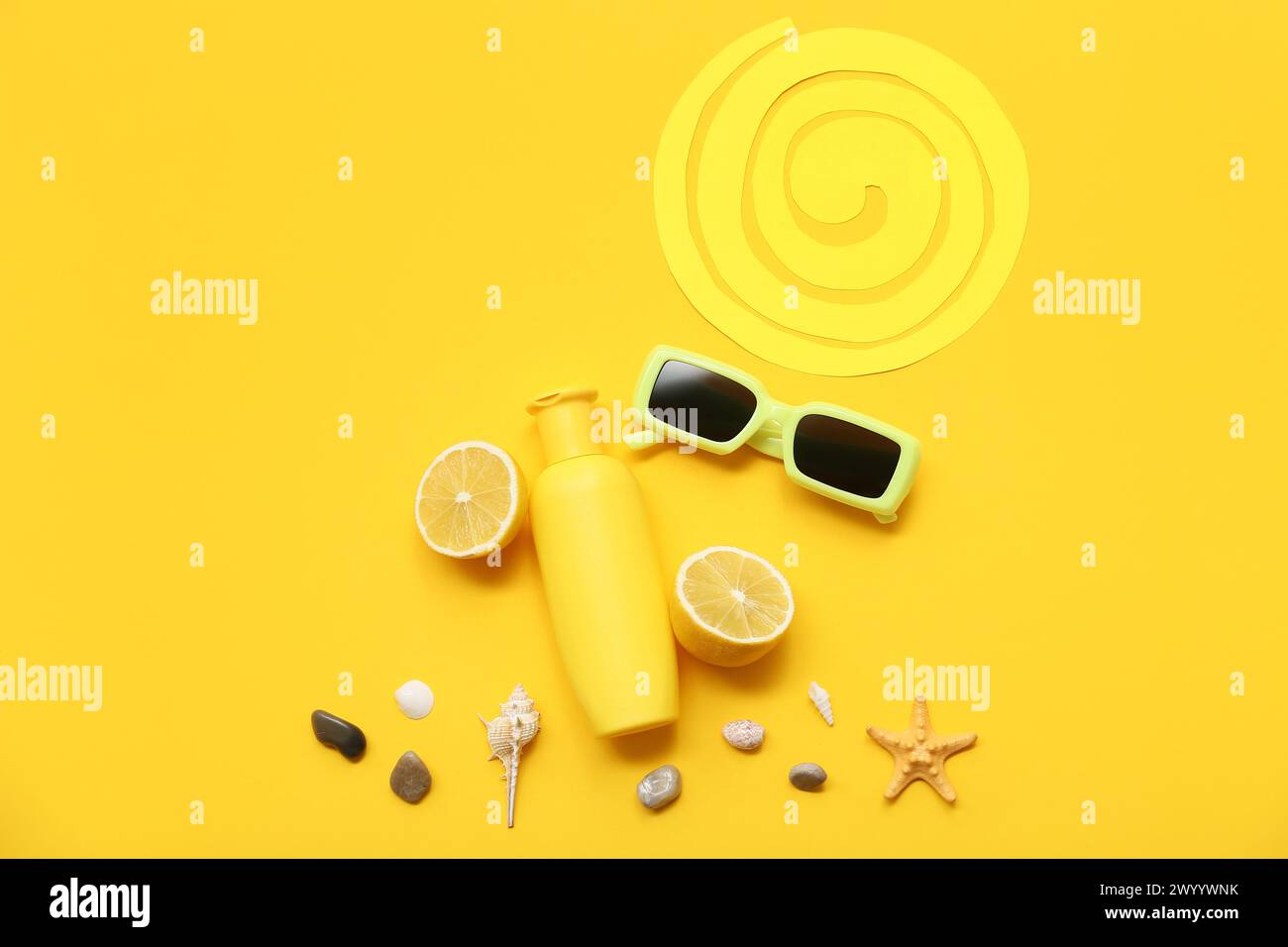 Bottle of sunscreen cream, lemon, sunglasses, paper sun figure and ...
