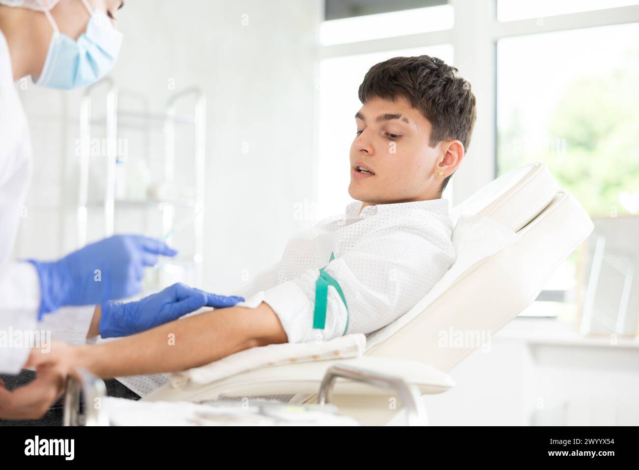 Anesthesiologist doctor injecting pain medication into vein of man ...