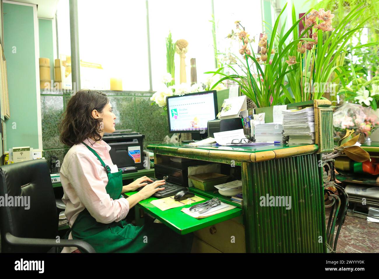 Florist in flower shop, sitting in desk Stock Photo - Alamy