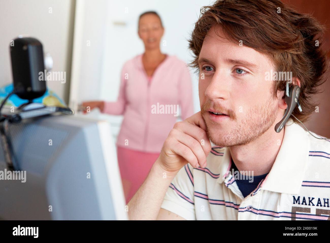Mother calling son who is looking at computer in his room Stock Photo ...