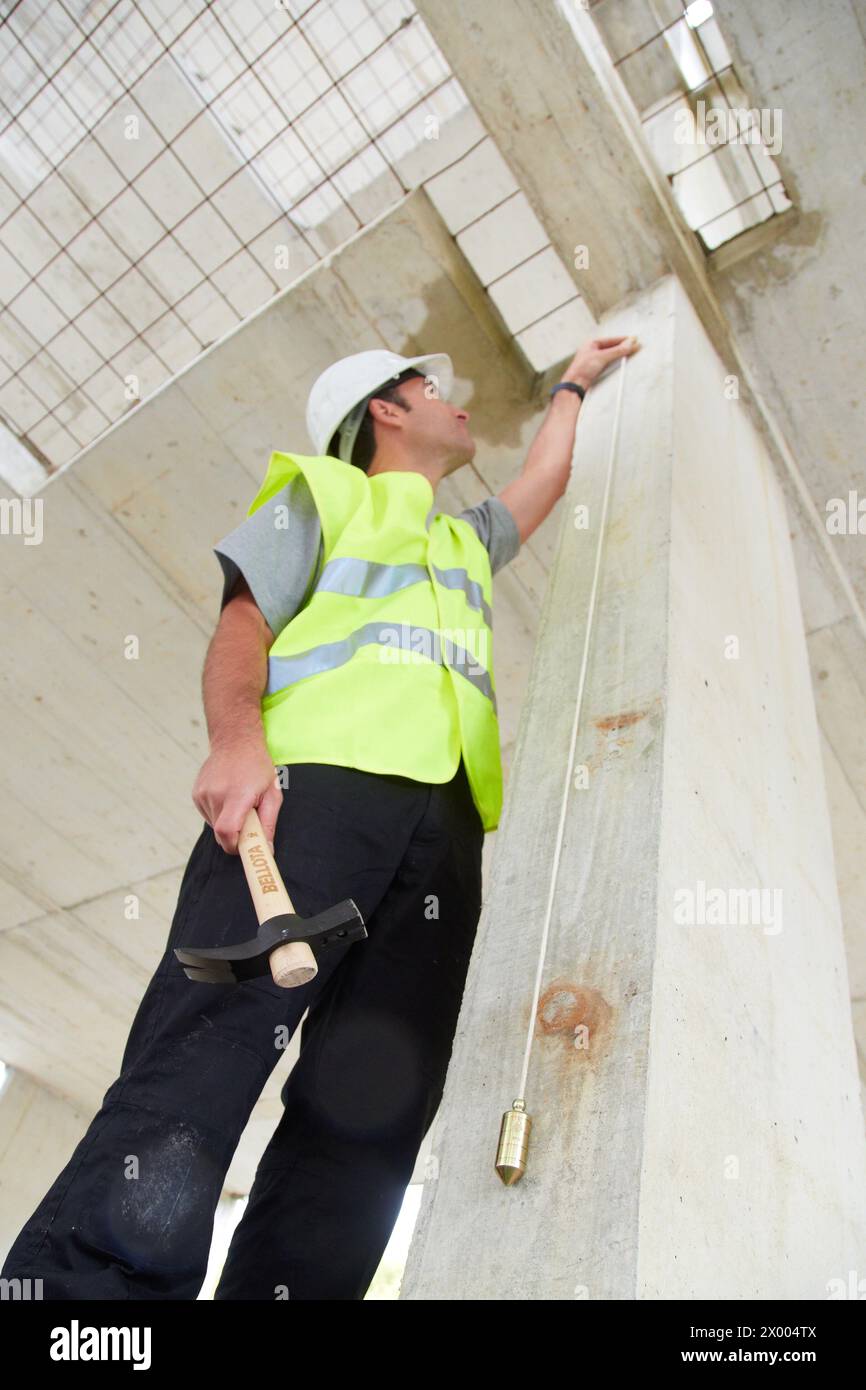 Worker with protective equipment, PPE, Checking and aligning vertical ...