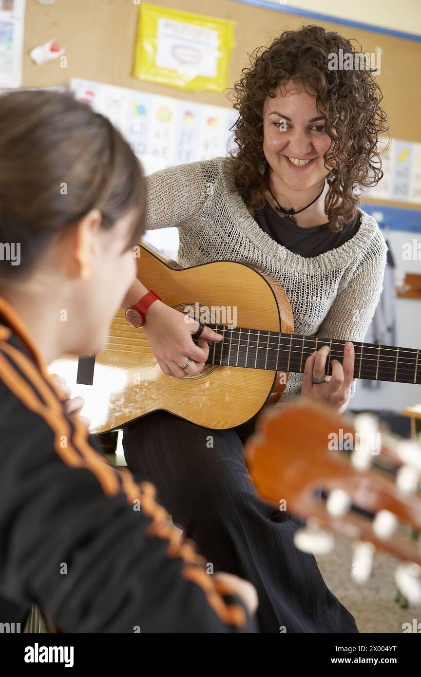 Music teacher, guitar instruction Stock Photo - Alamy
