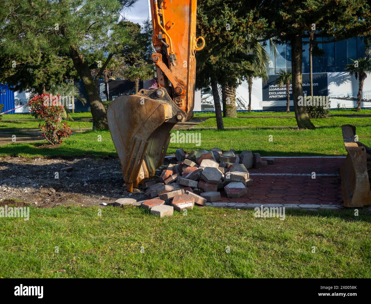 Excavator bucket at road works. Paving stone repair. Men at work Stock ...