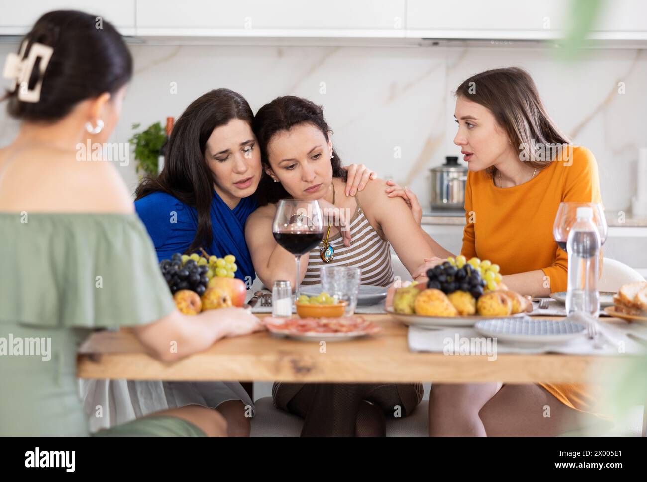 Group of female friends calming adult woman Stock Photo - Alamy