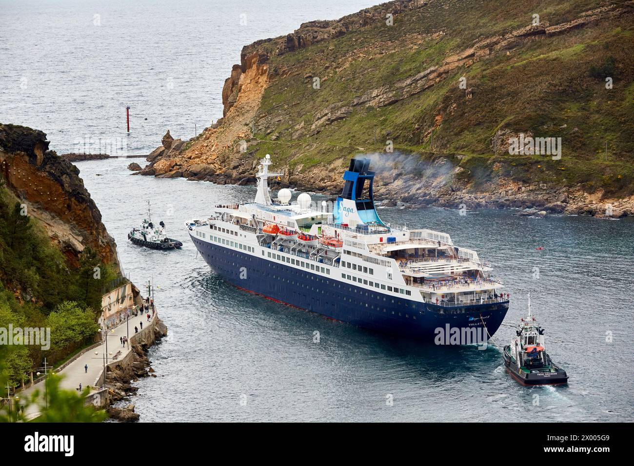 Tugboat and cruise liner. Passenger ship. Tug maneuvers. Pasaia Port ...