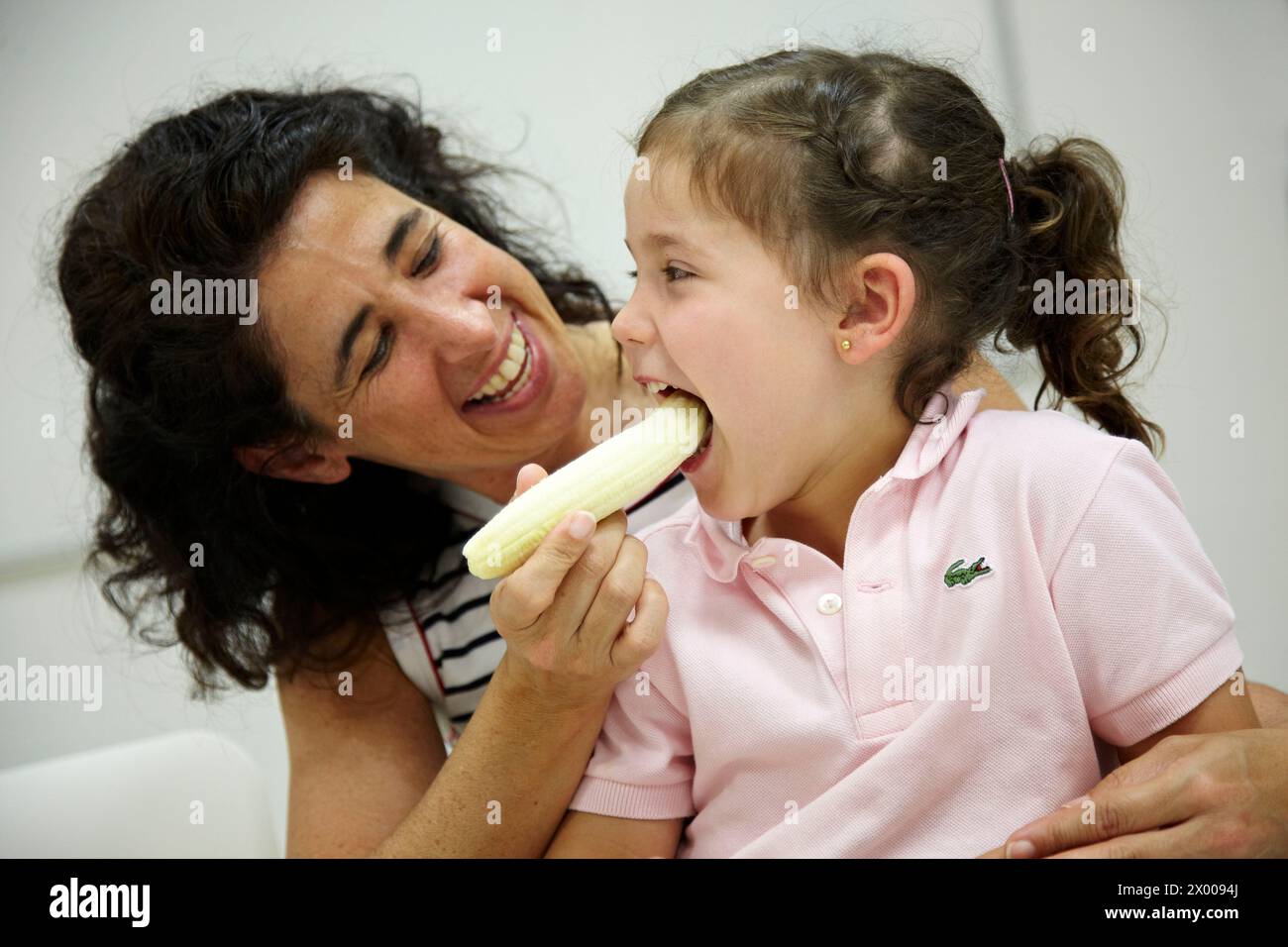 Mother giving a banana to her daughter, tasting session in sensory ...