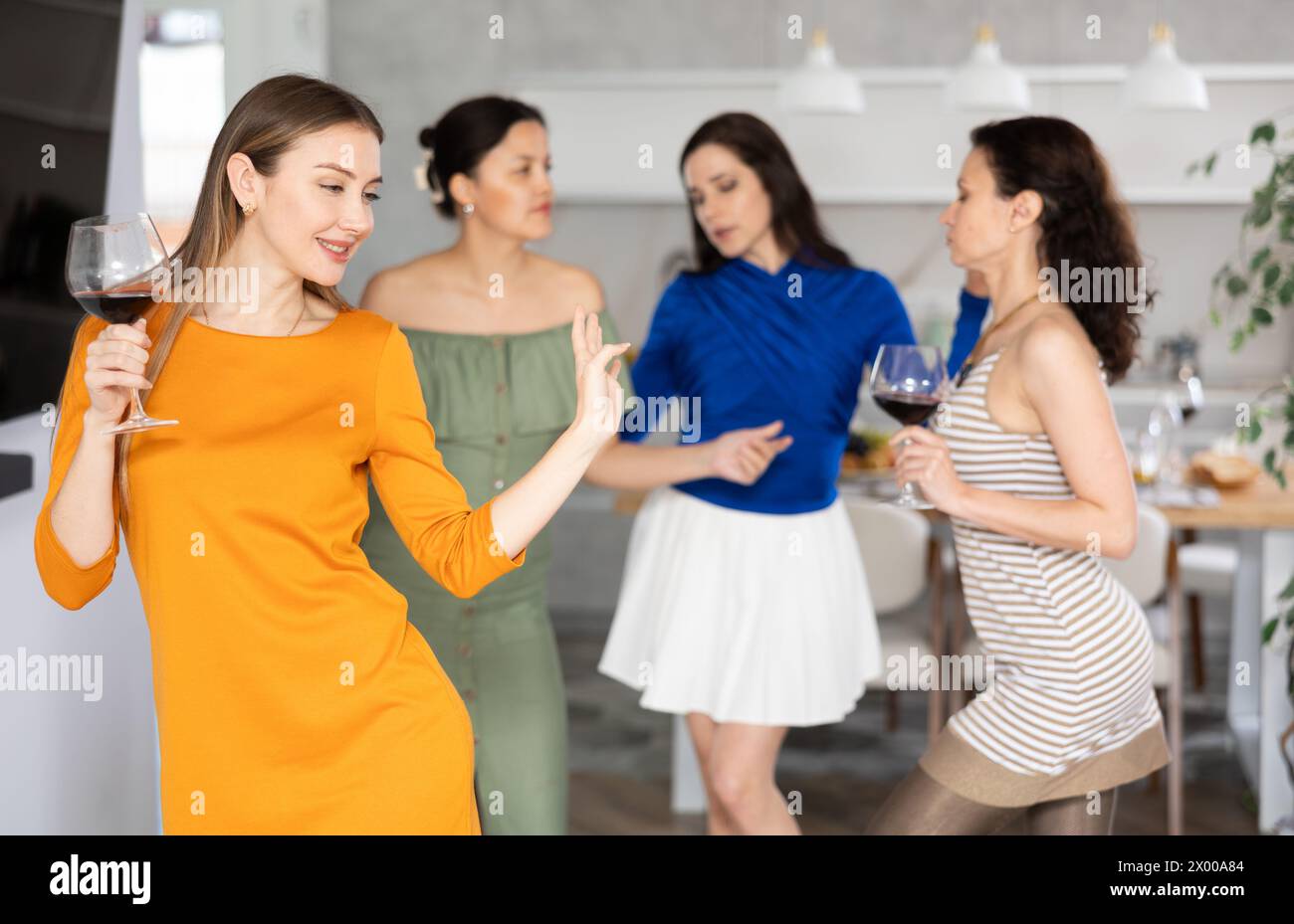 Cheerful woman dancing with wine glass at friendly house party Stock ...