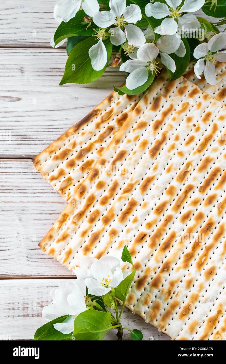Happy Passover flatlay. Jewish matzo bread and flowers on white wooden ...