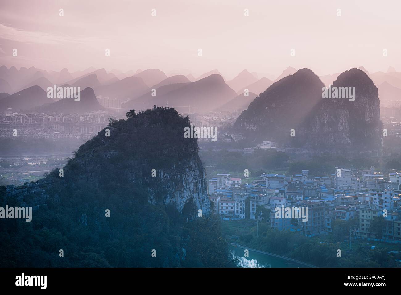 Limestone mountains at the sunset surrounded by the city buildings ...