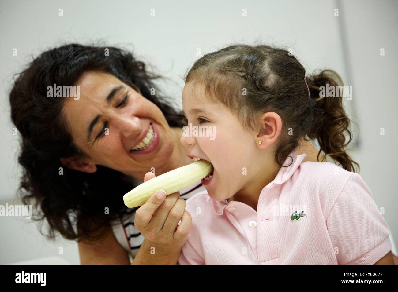 Mother giving a banana to her daughter, tasting session in sensory ...