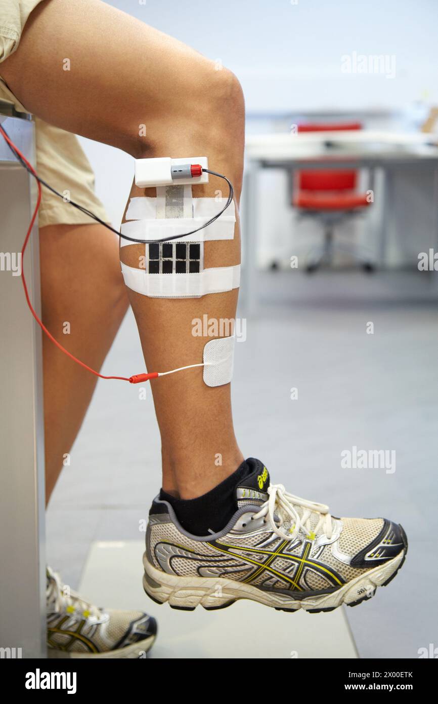Researcher placing multipad electrodes in the leg to control ...