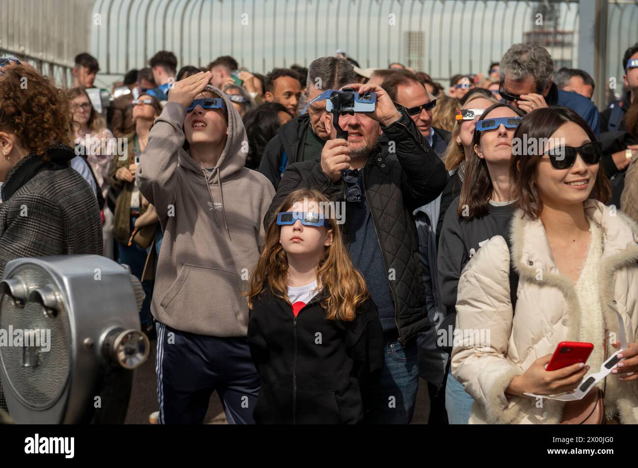 NEW YORK, NEW YORK - APRIL 08: People watch a partial solar eclipse ...