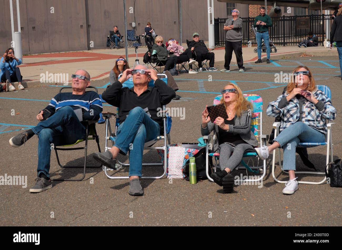 Attendees wear glasses to see a partial solar eclipse outside of the Cradle of Aviation Museum's ...