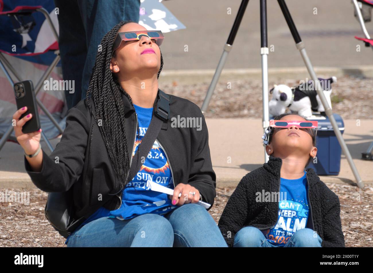 Attendees wear glasses to see a partial solar eclipse outside of the Cradle of Aviation Museum's ...