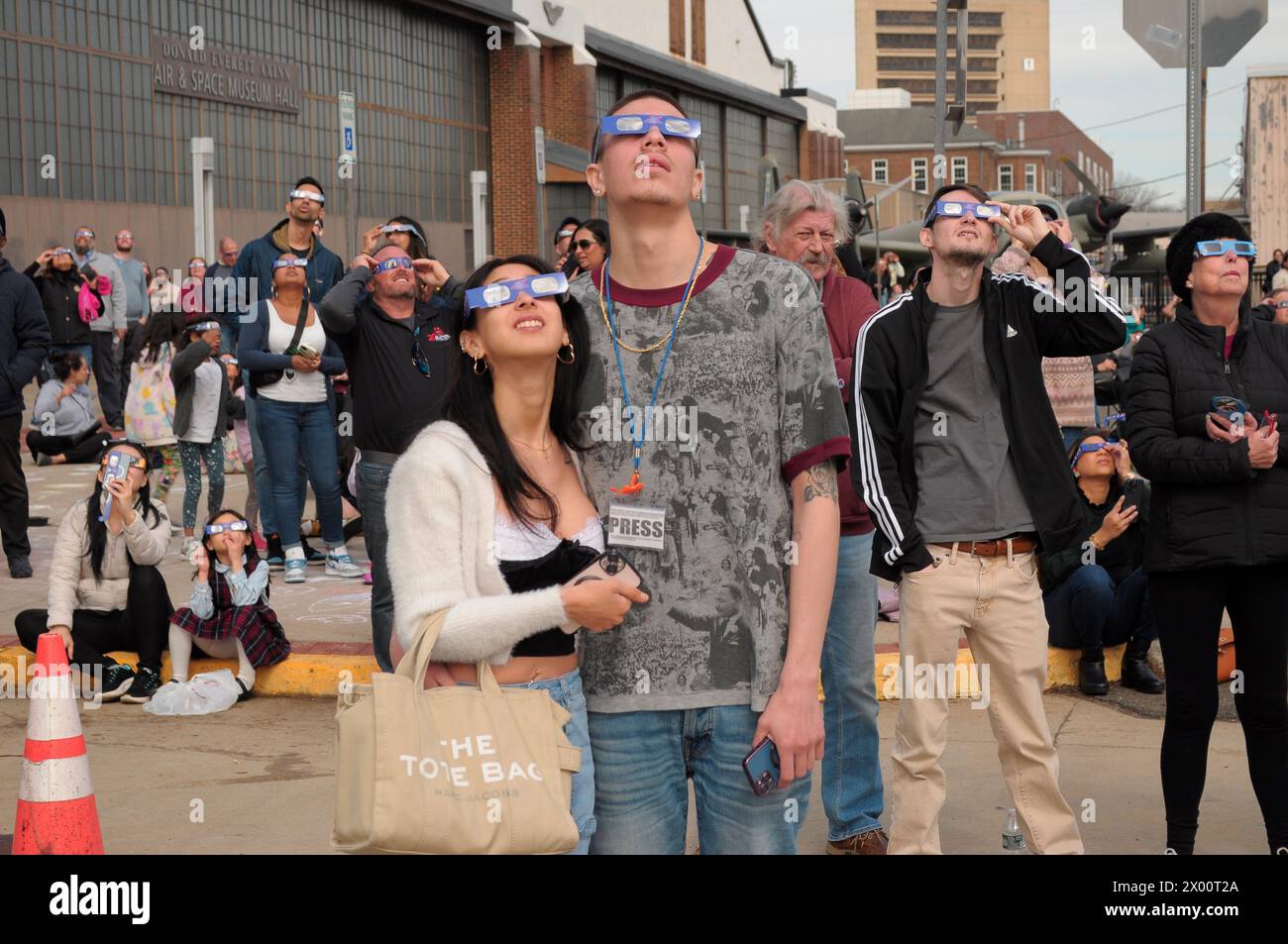 Attendees wear glasses to see a partial solar eclipse outside of the Cradle of Aviation Museum's ...