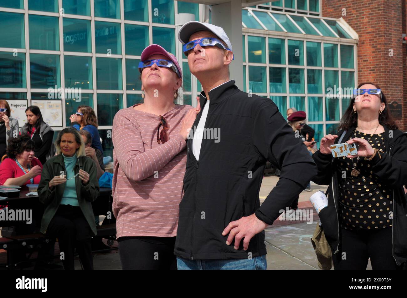 Attendees wear glasses to see a partial solar eclipse outside of the Cradle of Aviation Museum's ...
