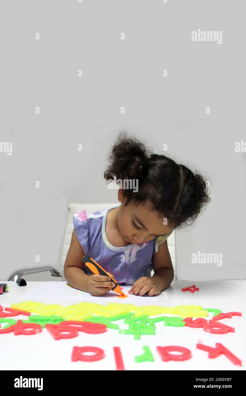 3 year old Latina brunette girl with curly hair draws as therapy for ...