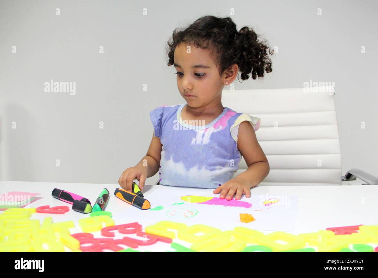 3 year old Latina brunette girl with curly hair draws as therapy for ...