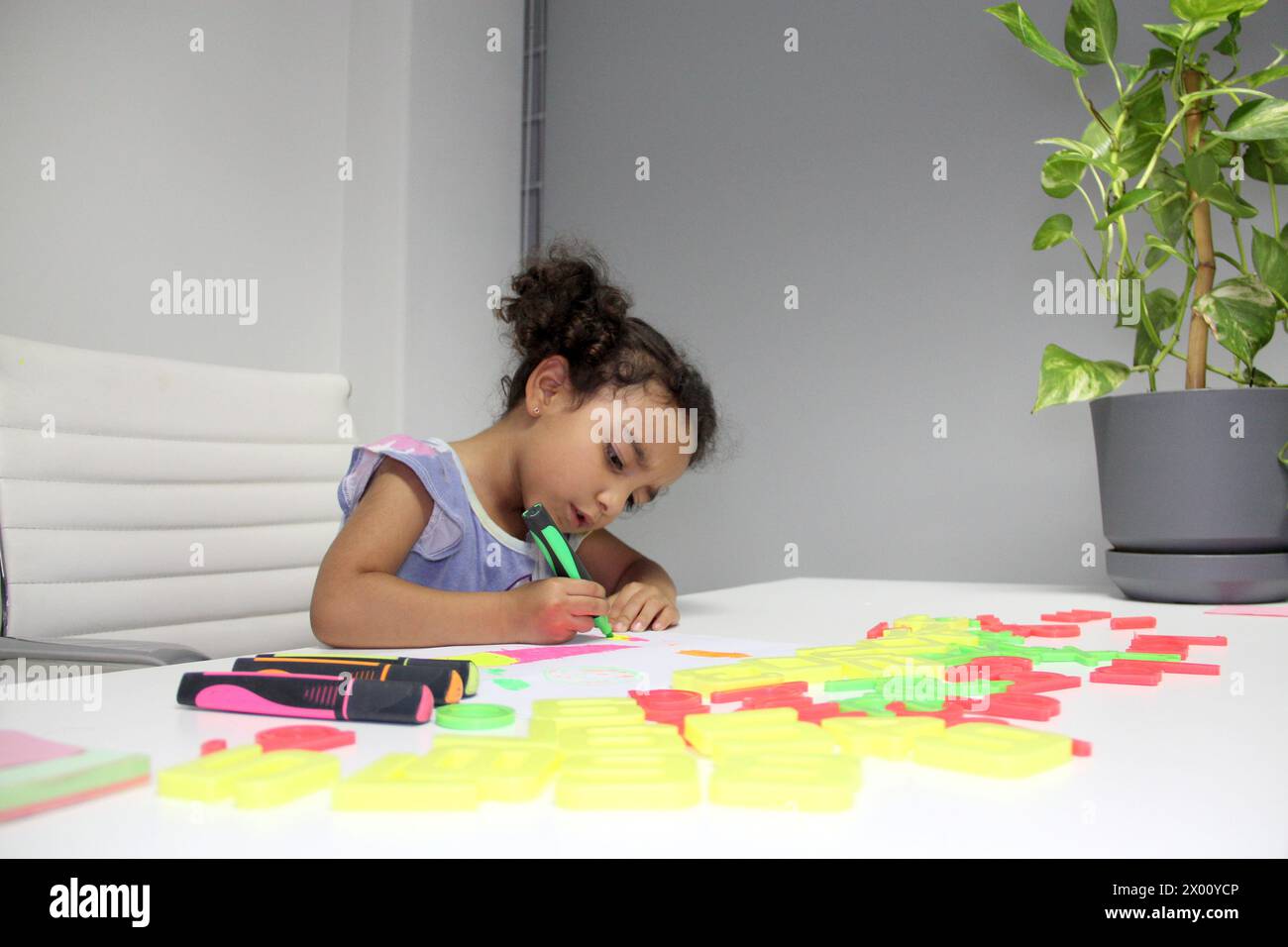 3 year old Latina brunette girl with curly hair draws as therapy for ...