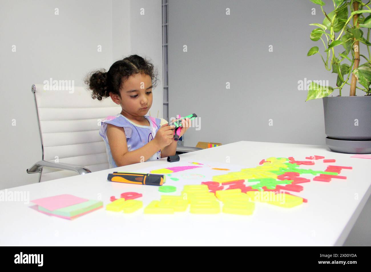 3 year old Latina brunette girl with curly hair draws as therapy for ...