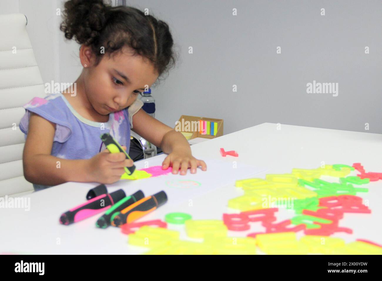 3 year old Latina brunette girl with curly hair draws as therapy for ...