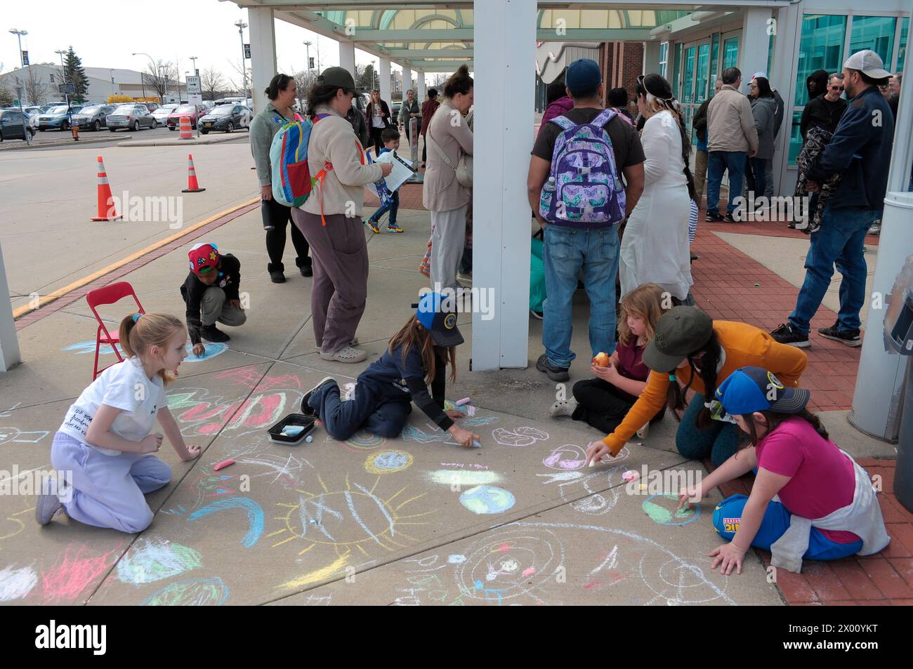 Attendees draw chalk sketches on the ground outside of the Cradle of ...