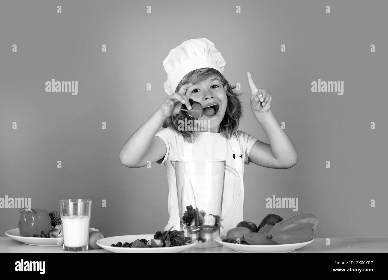 Portrait of chef child in cook hat hold spinach. Cooking at home, kid ...