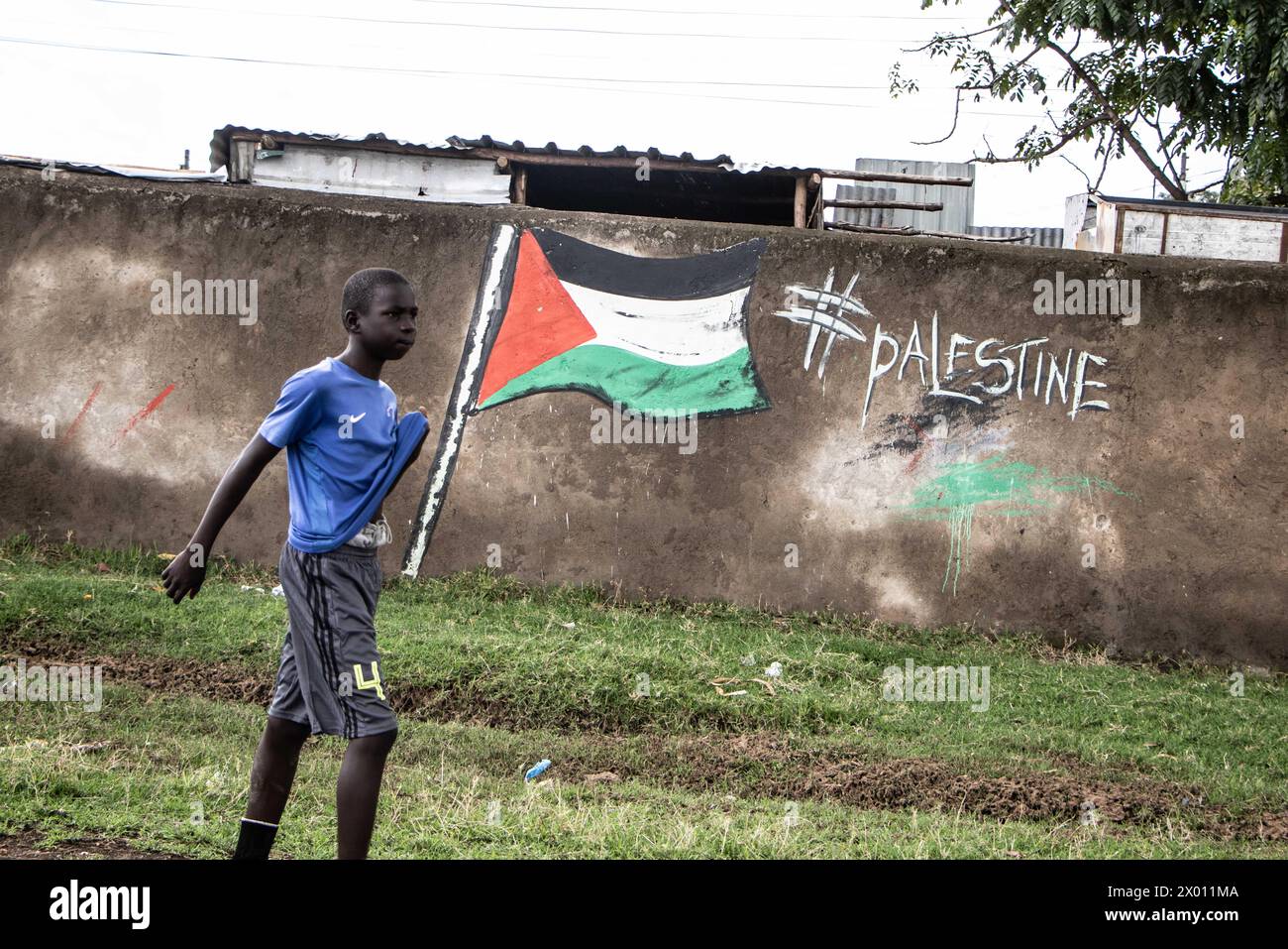 A boy walks past a mural featuring a Palestinian flag in Bondeni ...