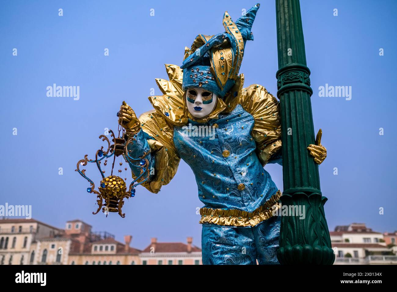 A masked person in a creative harlequin costume, posing at Canale ...