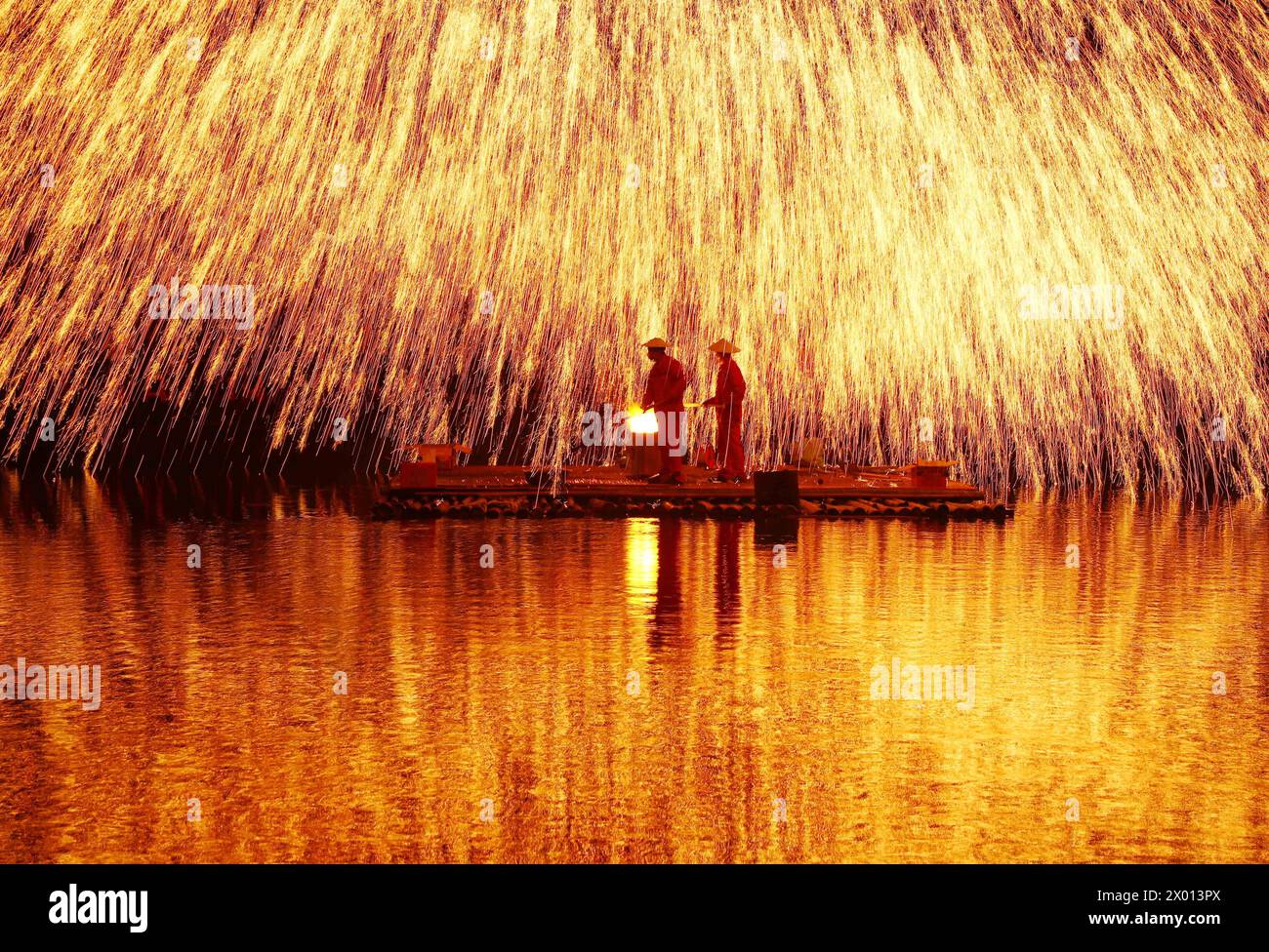An artist is hitting molten iron, which has been melted by high ...