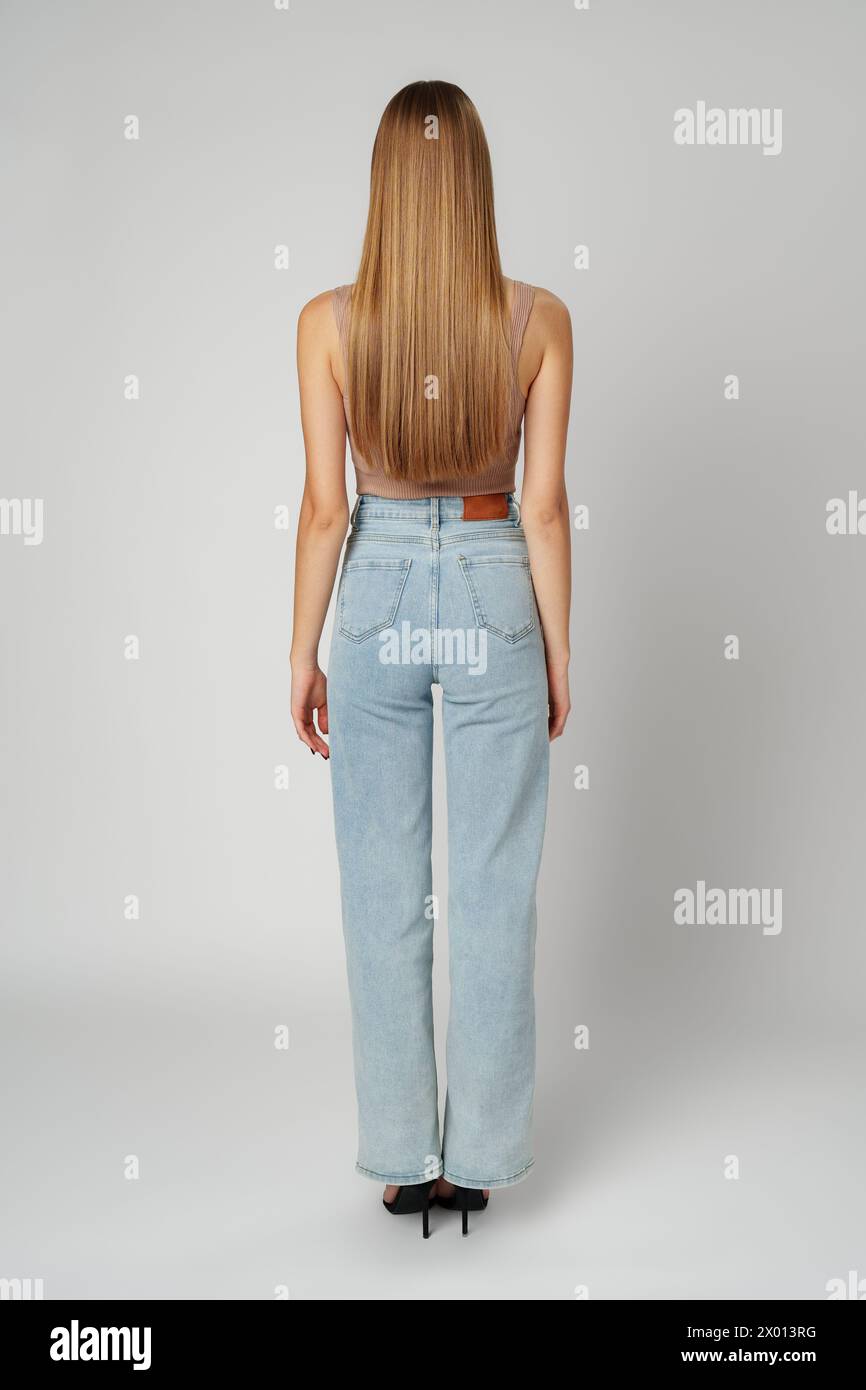 Back view full length photo of young woman with long hair on gray ...