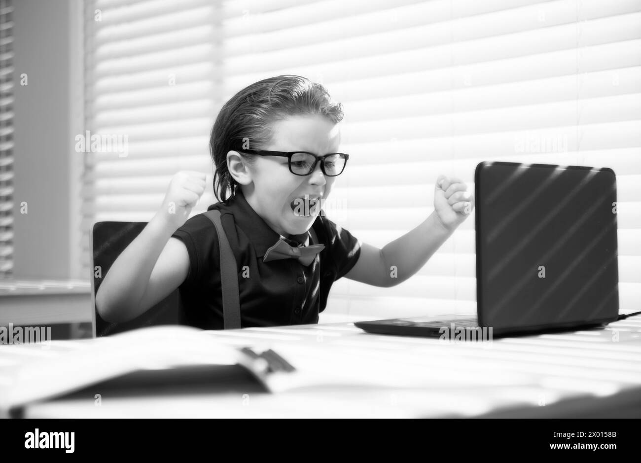Child boy using a laptop and study online lesson. Pupil at school. Cute ...