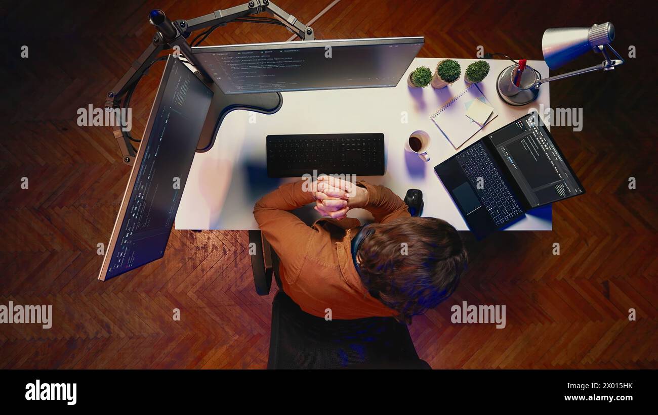 Aerial Shot Of Computer Scientist Listening Music While Writing Lines Of Code During Remote Job