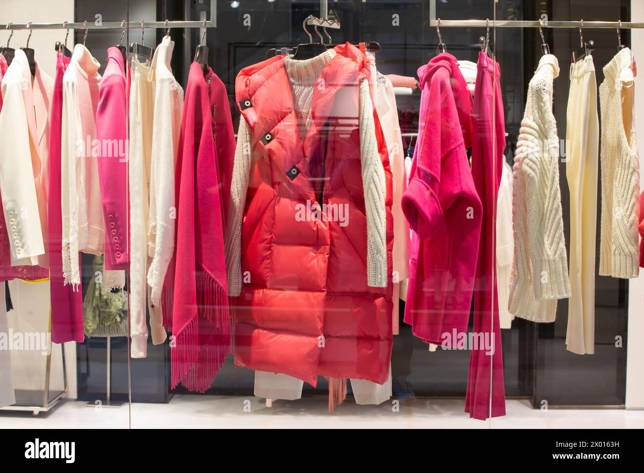 Women's clothing in red and white colors behind the glass of a store ...