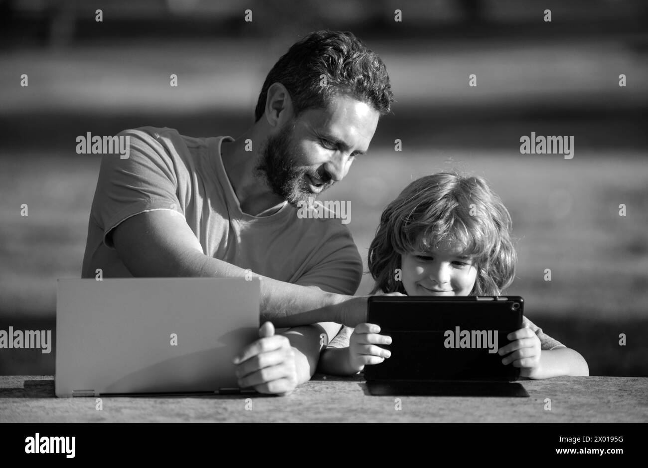 Happy father using laptop relax with schooler son holding laptop have ...
