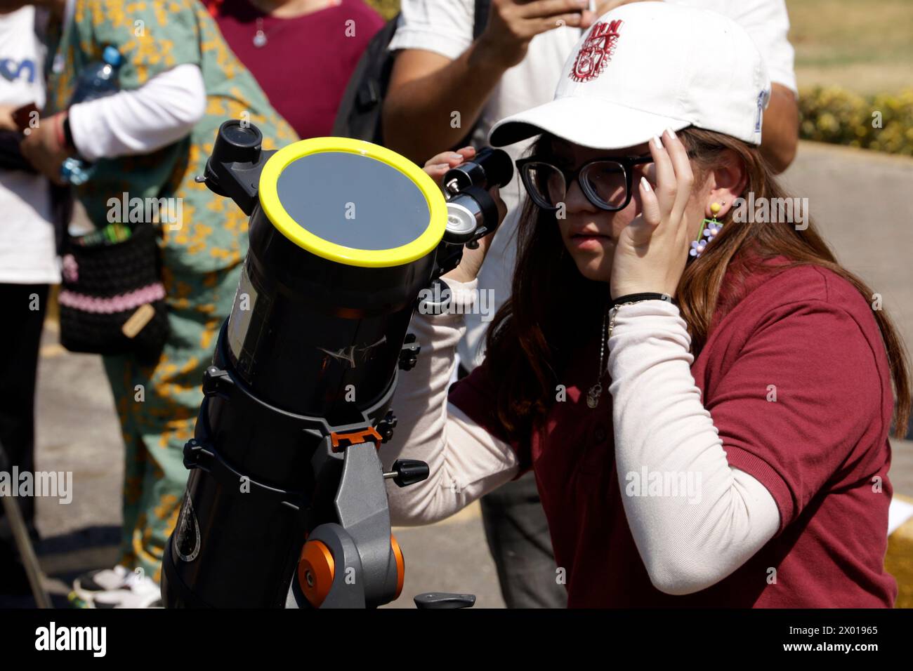 Non Exclusive: A person observes the solar eclipse through a telescope ...
