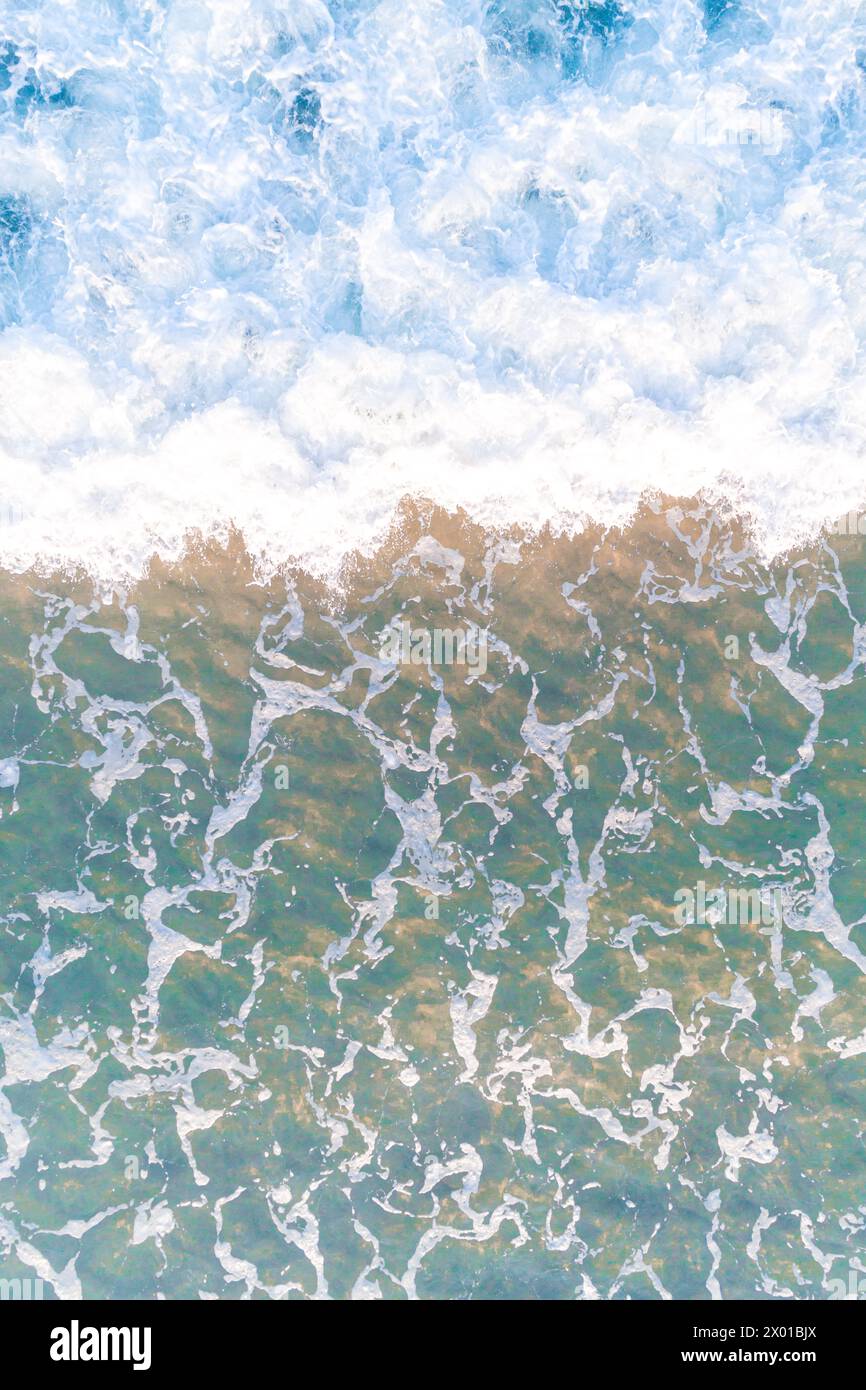 close up view of the sea water reaching the shore of the beach, texture ...