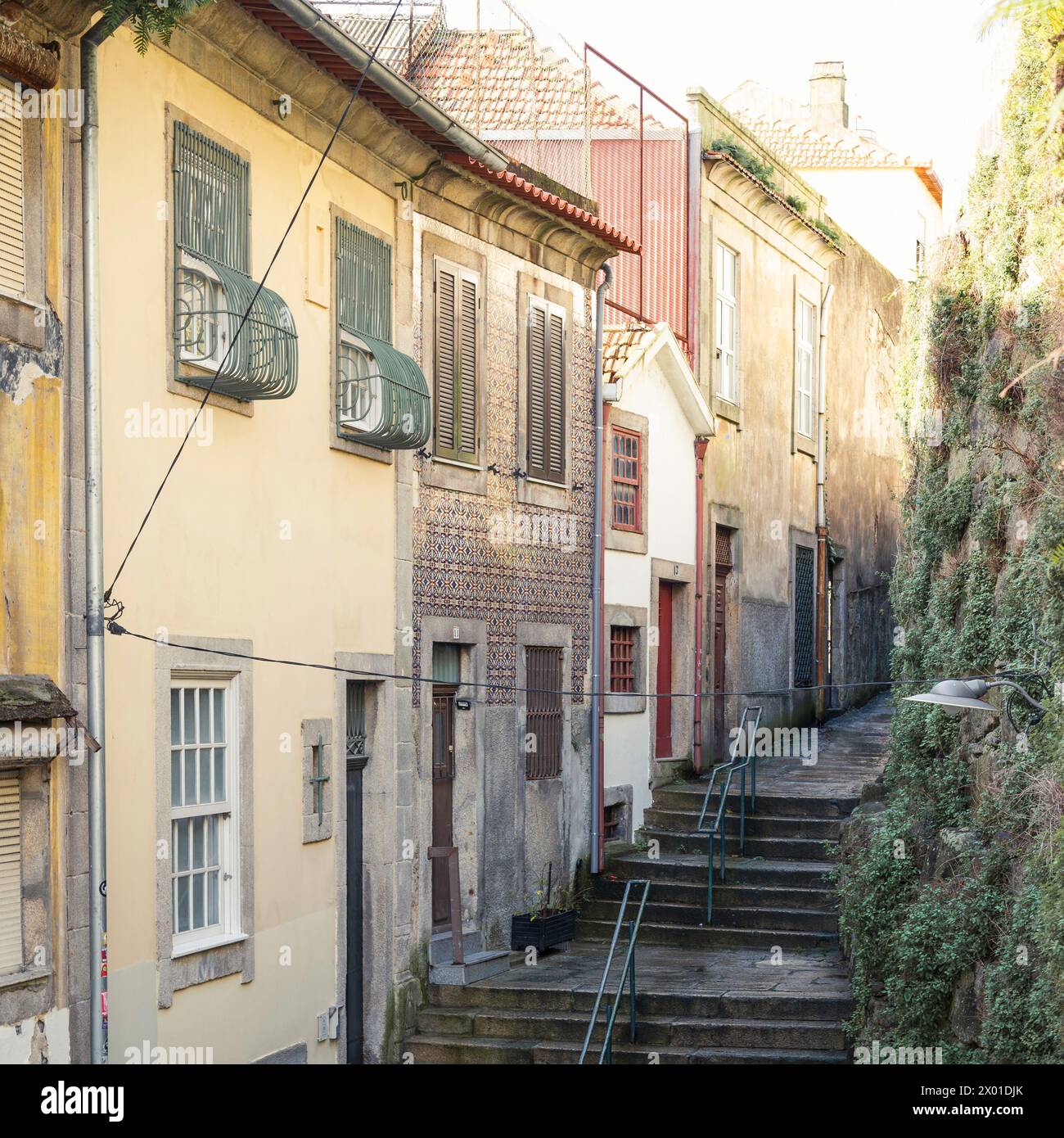 A quaint scene of a back street in Porto, with stone steps running past ...
