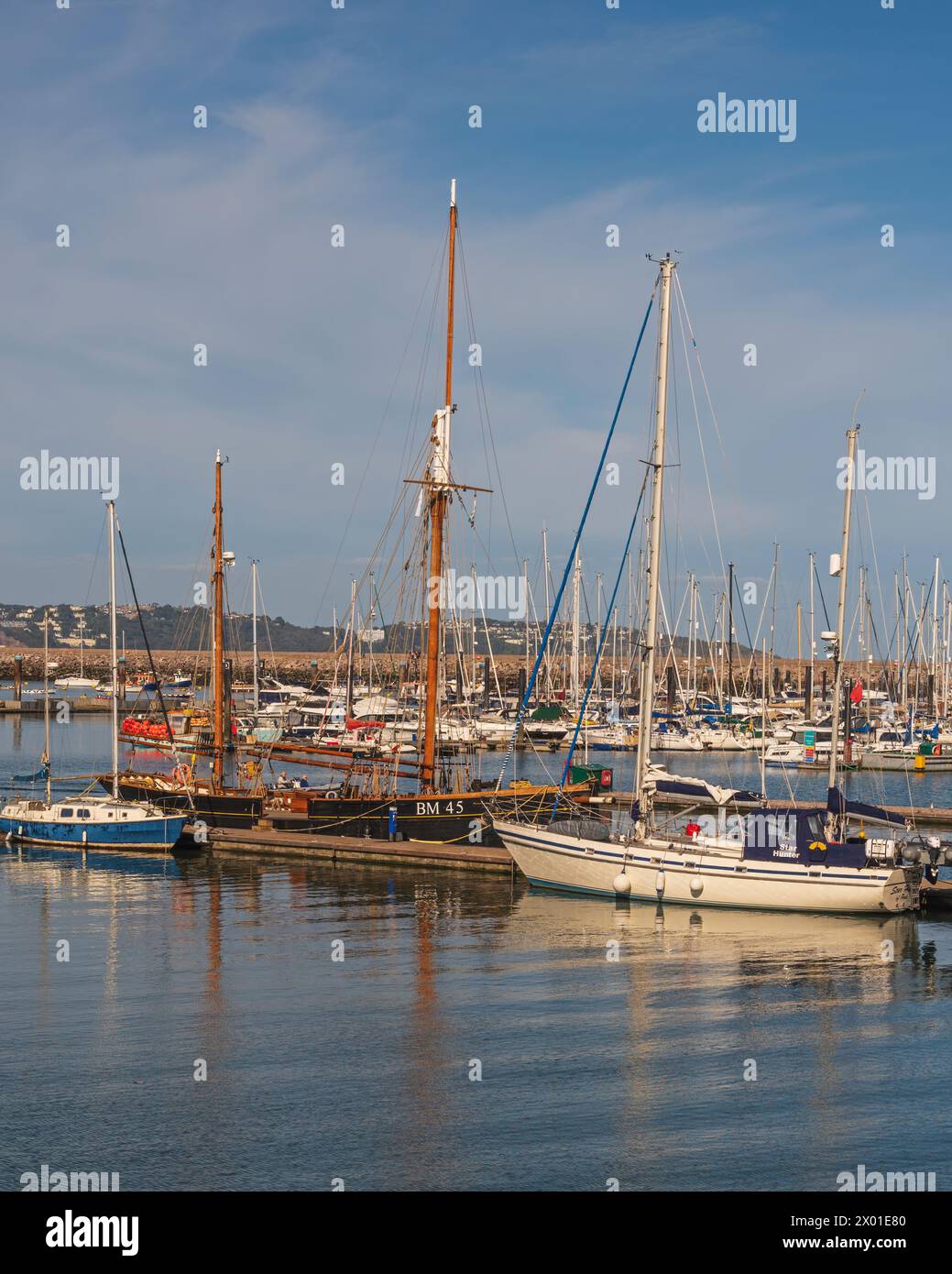 Pleasure craft moored along a floating jetty in the calm waters of the ...