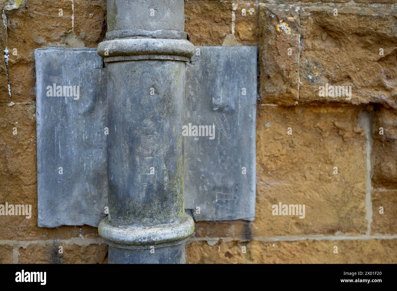 17th Century Lead downpipe detail on a yellow ironstone wall Stock ...