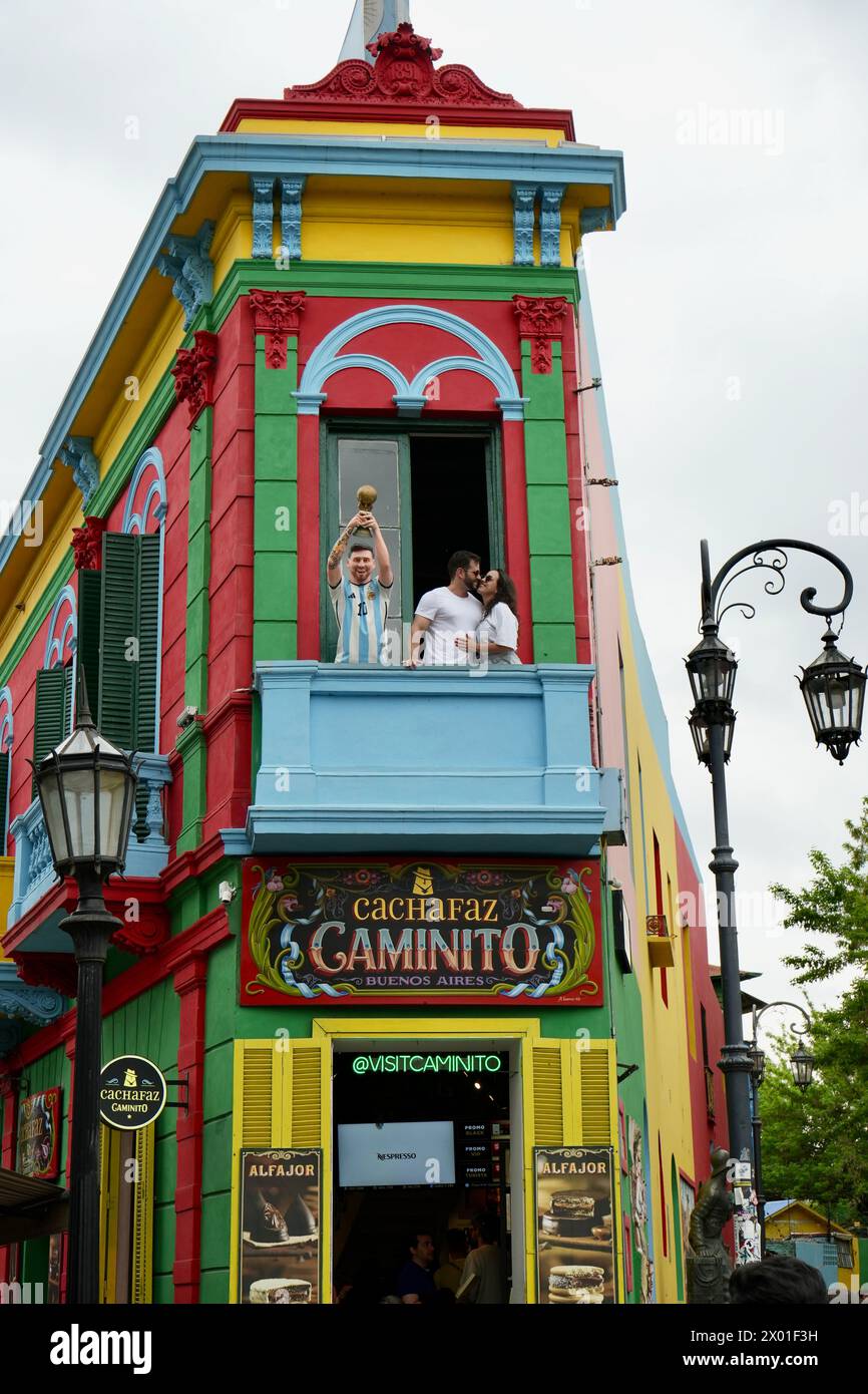 Couple pose next to a Lionel Messi model on a balcony on a Colorful ...